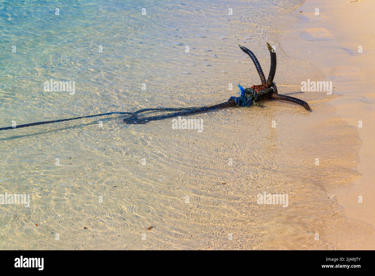 Small boat anchor on a shore of ocean Stock Photo - Alamy