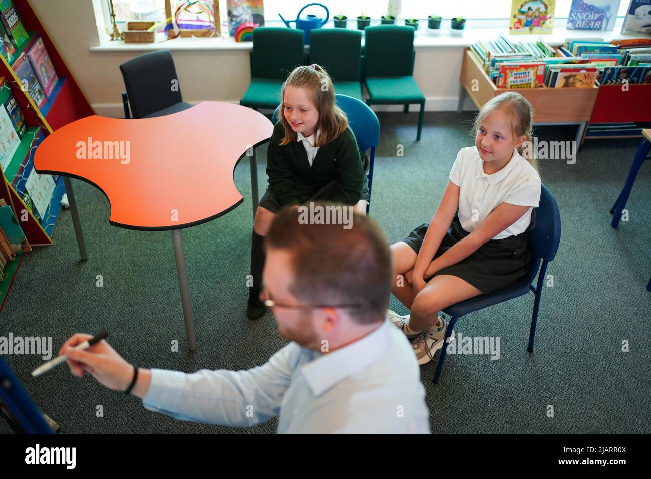 Ukrainian pupil Sofi (right) and her classroom buddy Sylvia being taught by Tom Ormston at ...