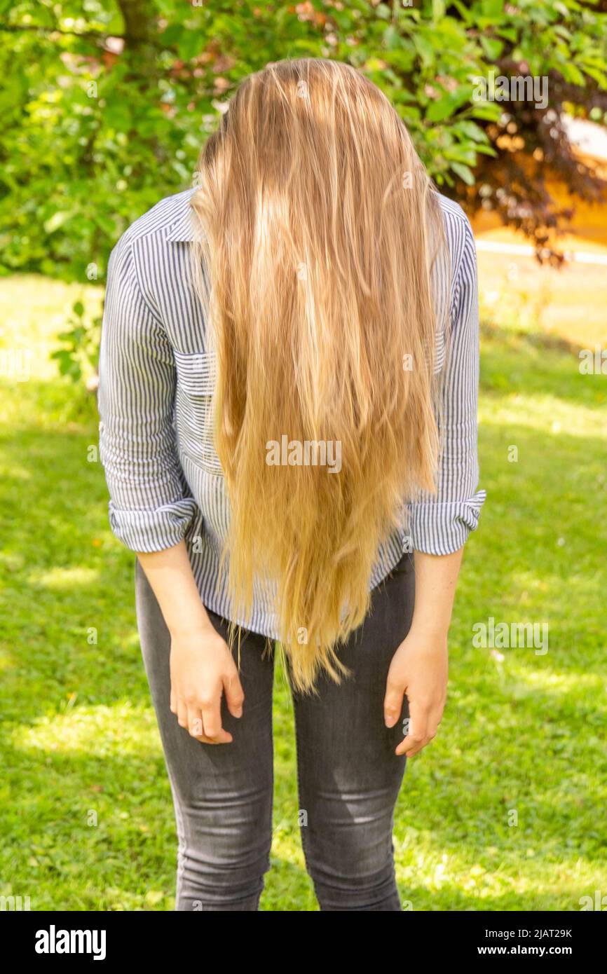 young blonde pretty girl with long hair in front of her face Stock ...