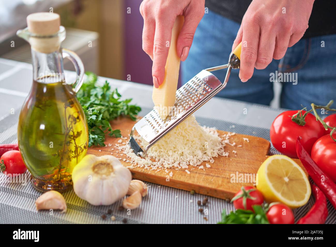 Woman grating parmesan cheese on a grater at domestic kitchen Stock ...