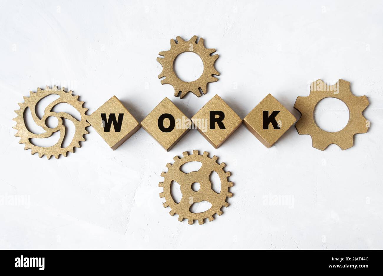 Word WORK made from letter blocks with cogwheels arranged on a concrete ...