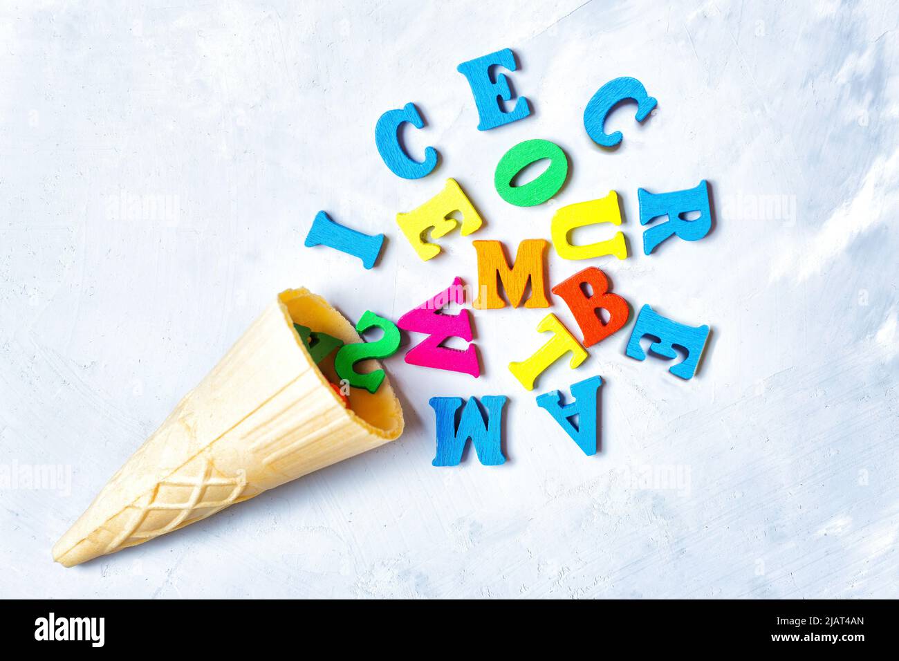 Waffle cone and multicolored wooden letters arranged into an ice cream ...