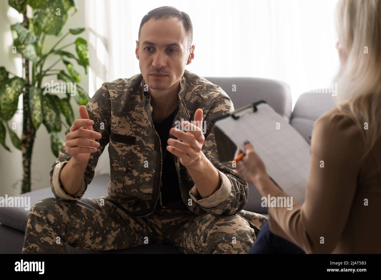 Psychologist making notes during therapy session with soldier, PTSD ...