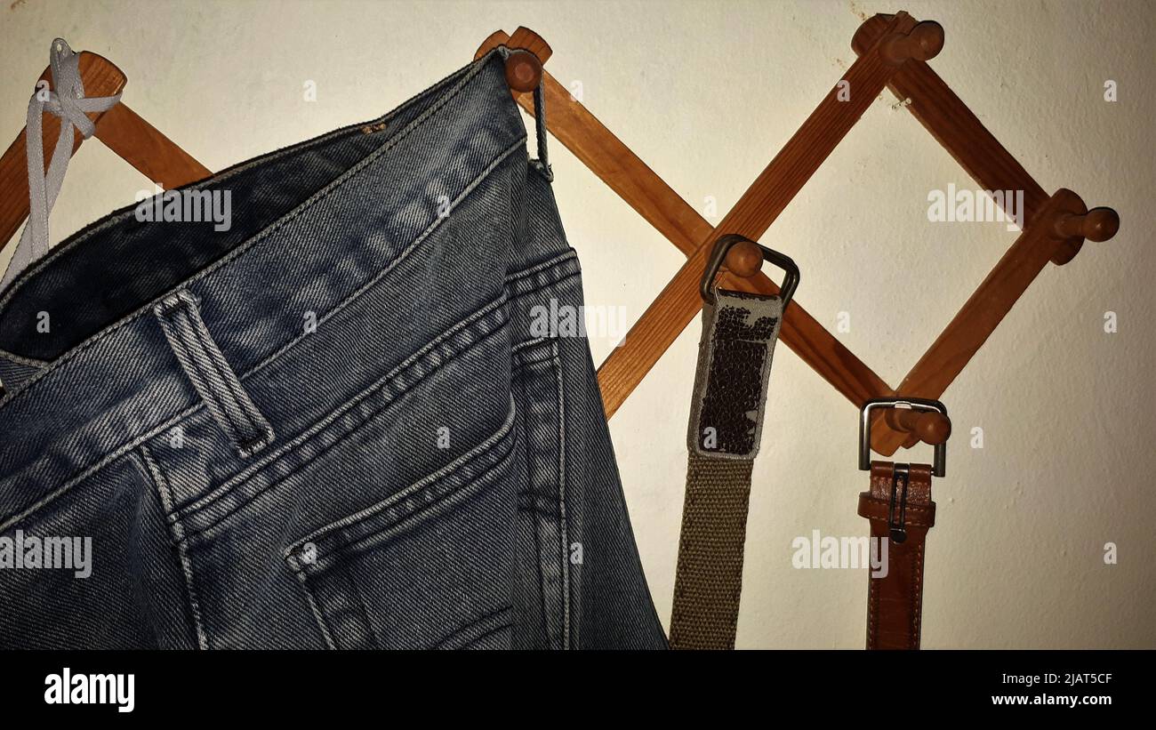 Faded jeans and vintage belts hanging side by side Stock Photo - Alamy