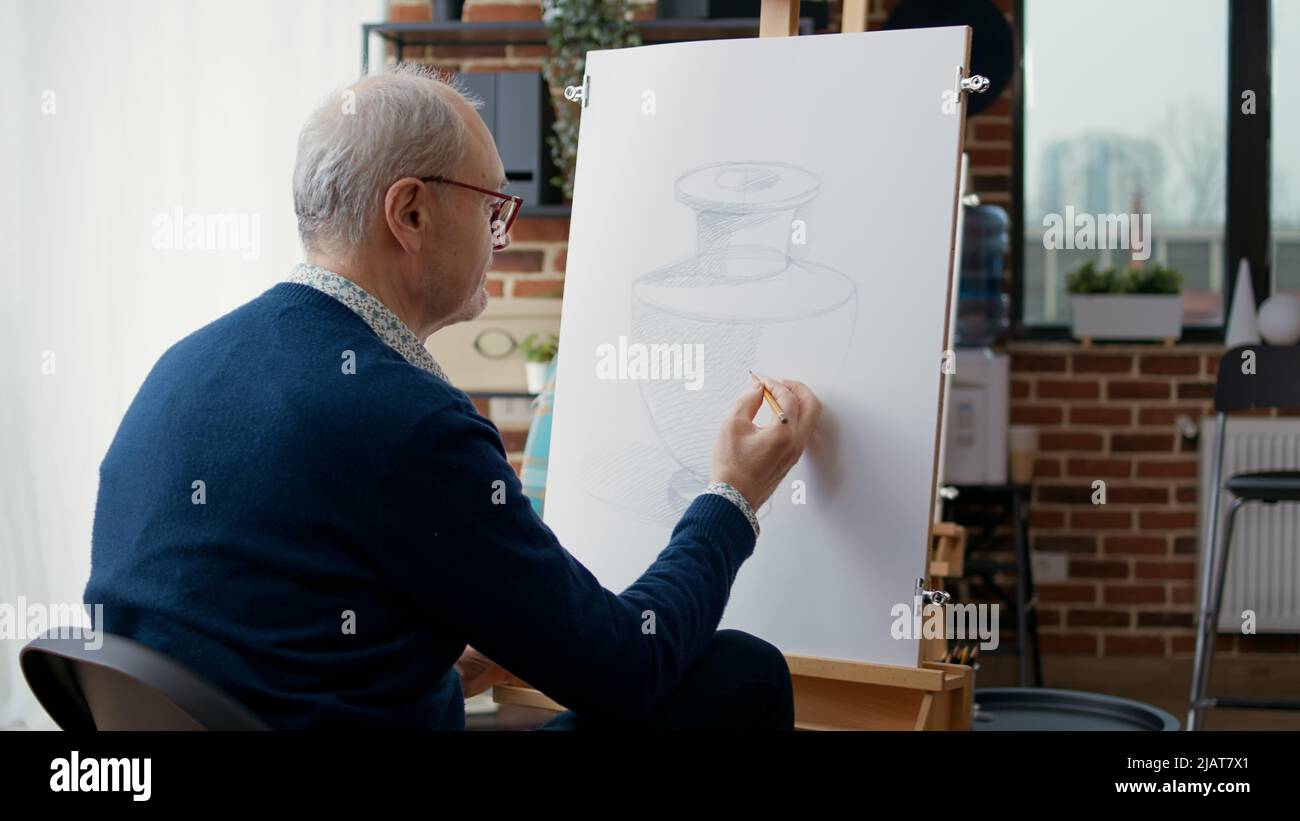Old man drawing vase model on canvas at art class lesson, attending ...