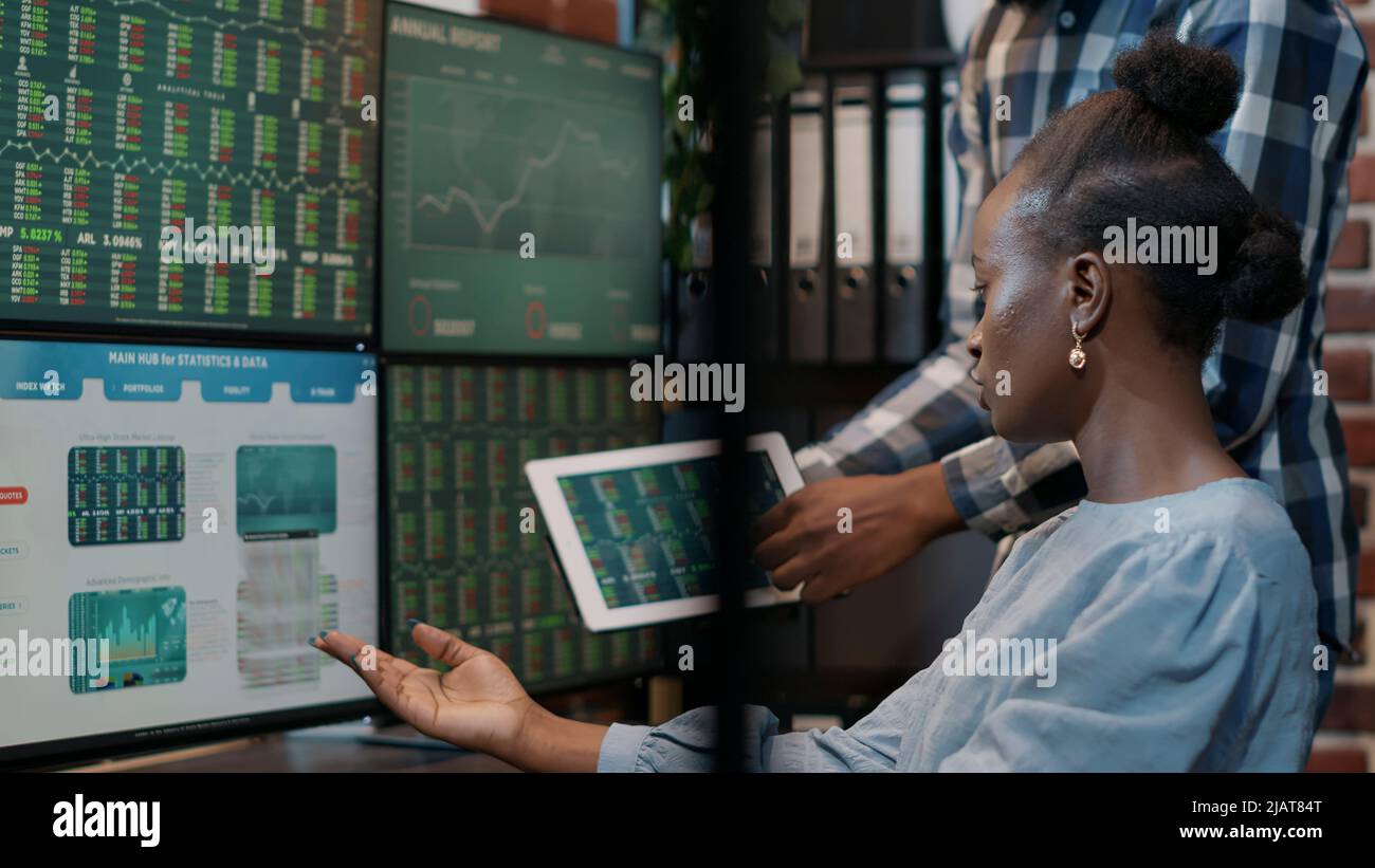 African american team working on forex investment growth, looking at ...