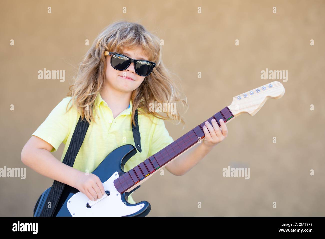 Child musician playing the guitar like a rockstar outdoor. Kid boy rock ...