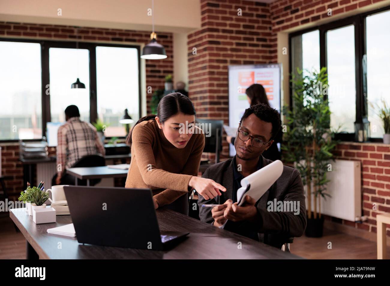 Paralyzed entrepreneur sitting in wheelchair and working with asian ...
