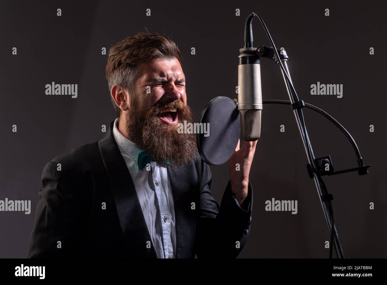 Singer man singing with a microphone in recording studio Stock Photo ...
