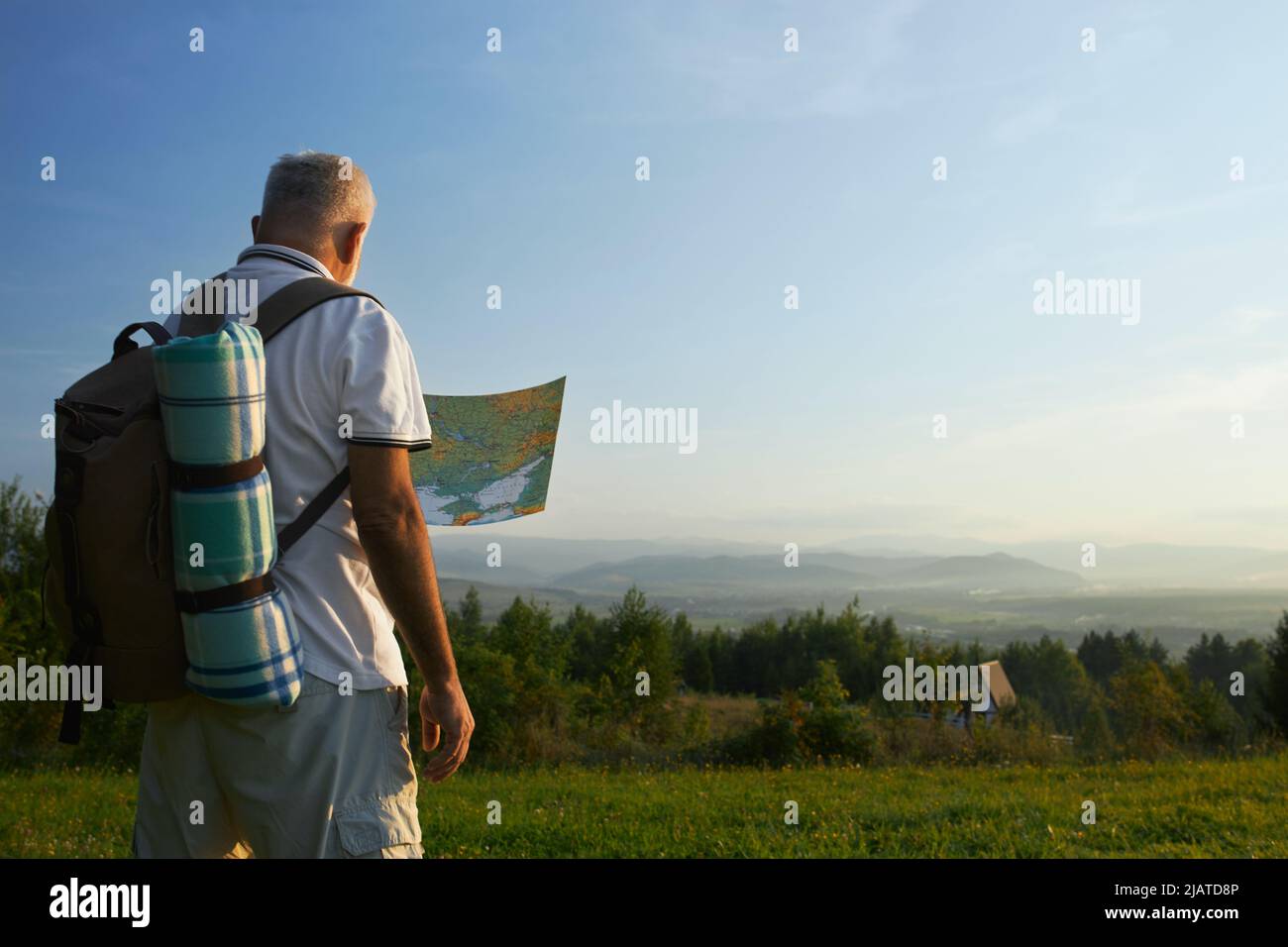 Back panoramic view of old male with gray hair wearing rucksack ...