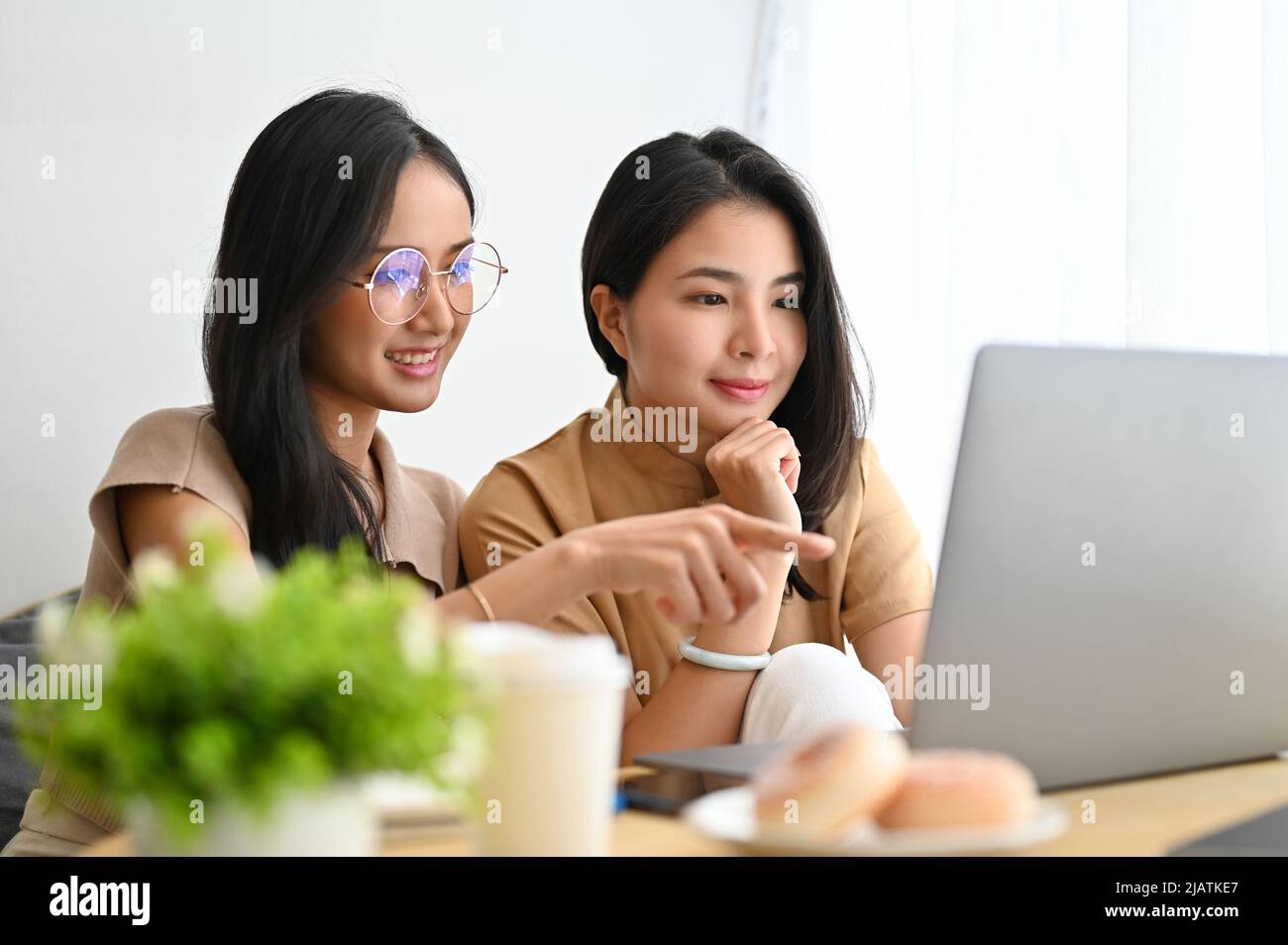 Focused and concentrated two asian female college student doing work ...