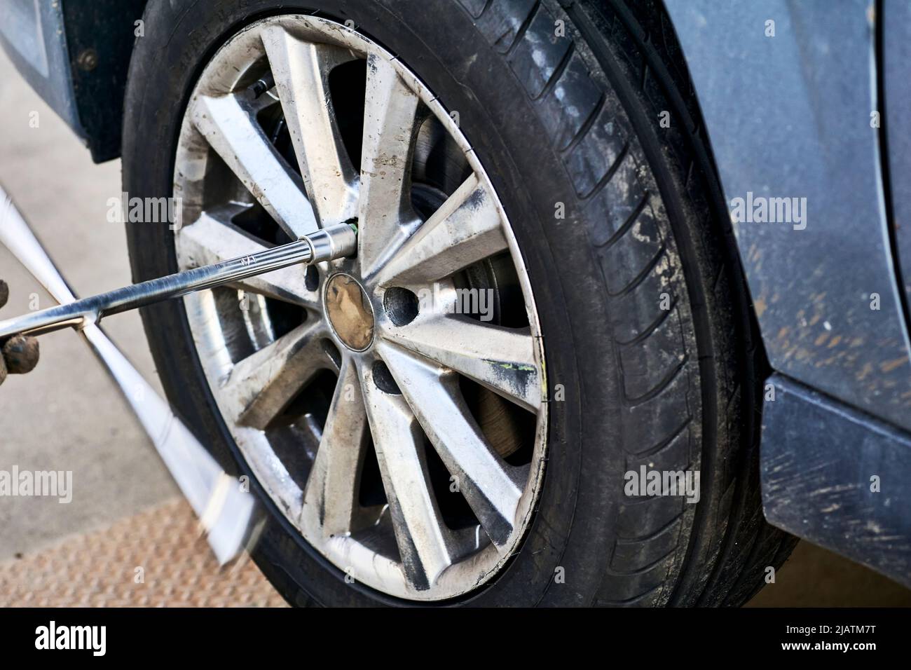 Service tire fitting. Workshop worker removing a wheel from a car Stock ...