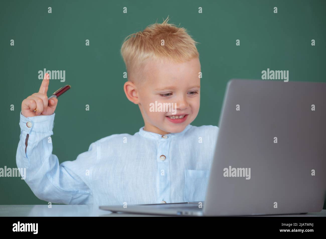 Cute excited school kid boy study in a classroom. Genius child programming, computer training ...