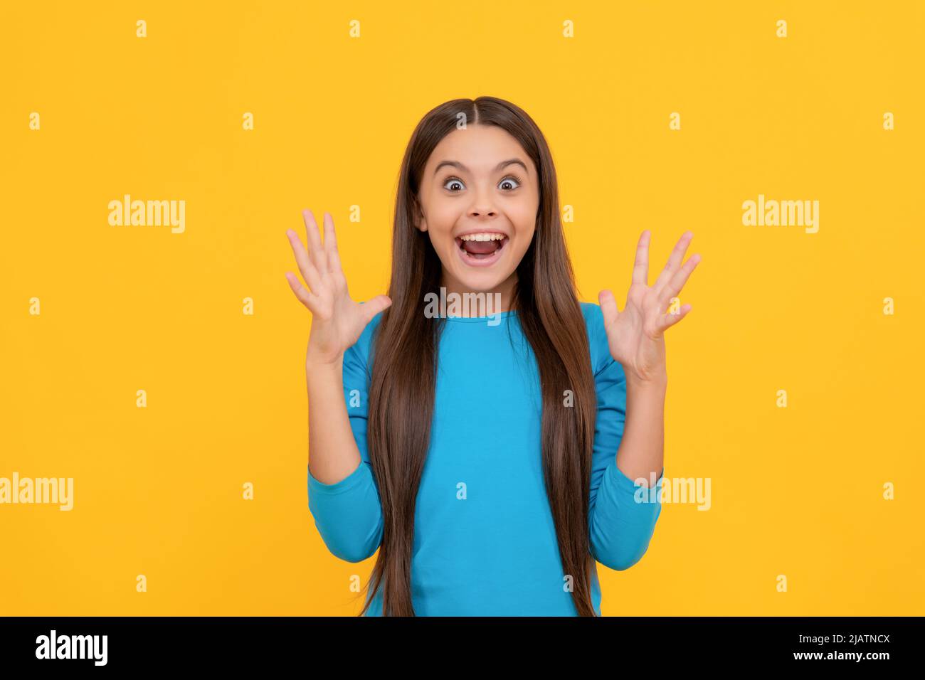 happy shocked kid with long hair on yellow background, wow Stock Photo ...