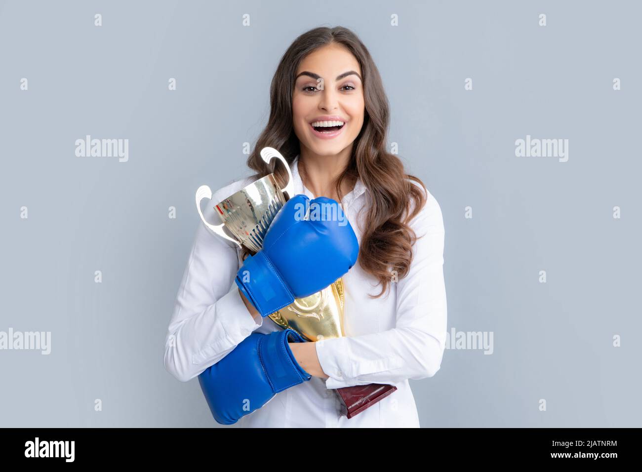 Business portrait of a woman in an office suit with boxing gloves and ...