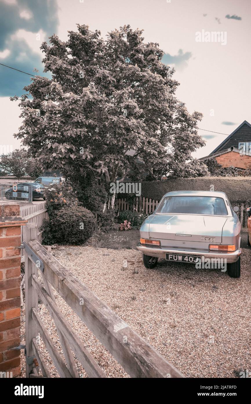 A classic car sits on the driveway of a cottage in the English ...
