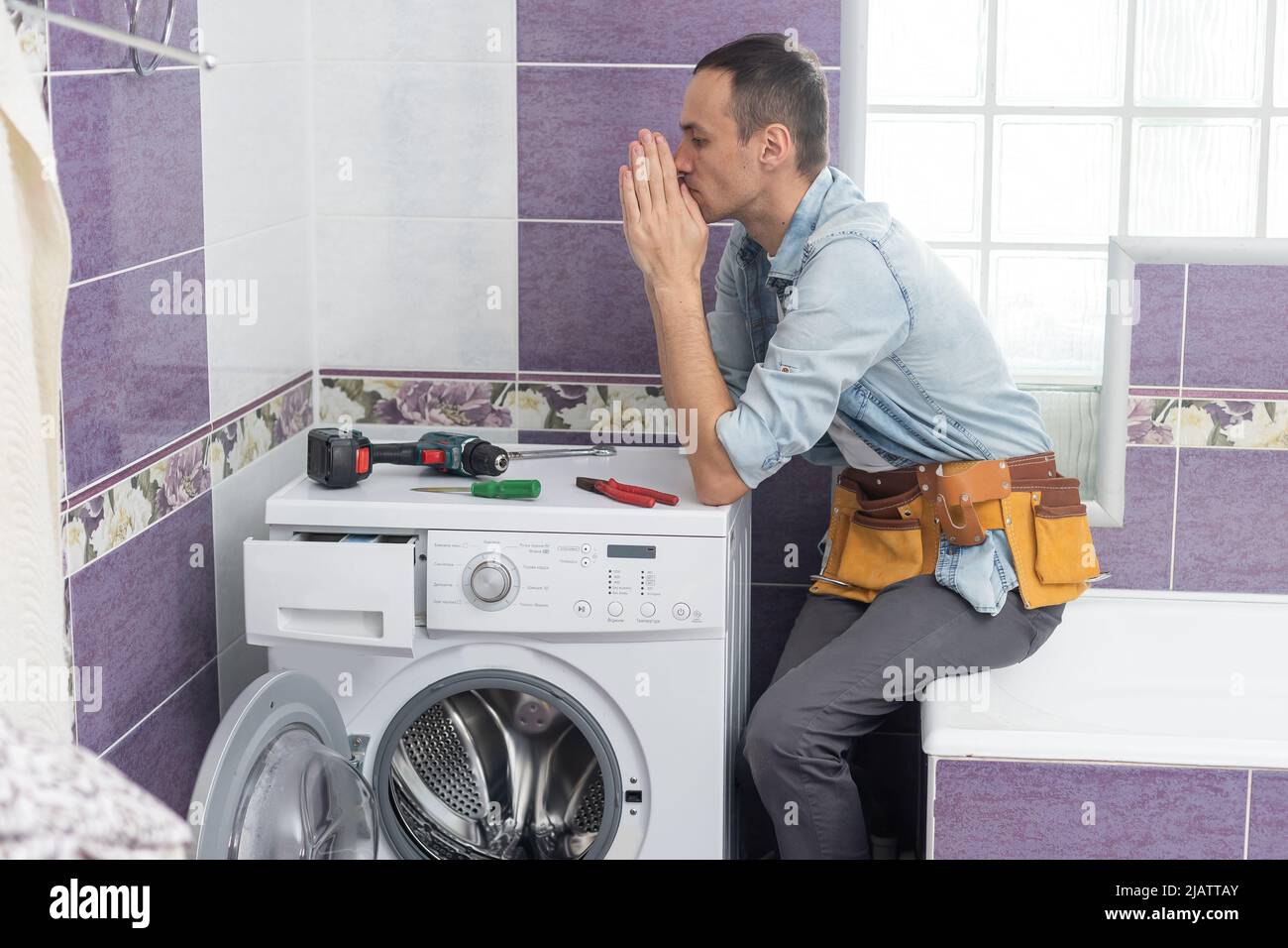 Man repairs washing machine hi-res stock photography and images - Alamy
