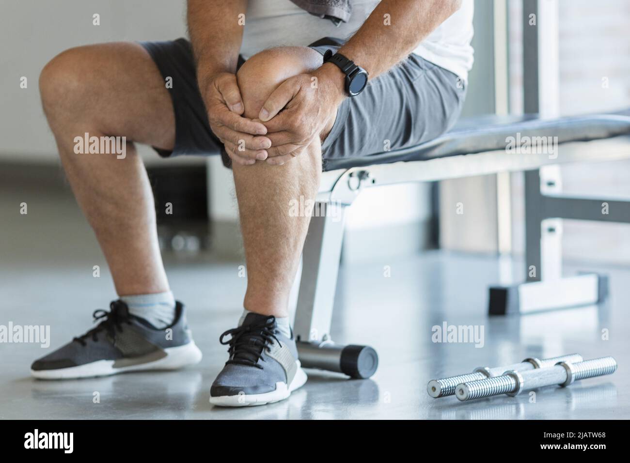 Active senior man in gym with knee injury Stock Photo - Alamy