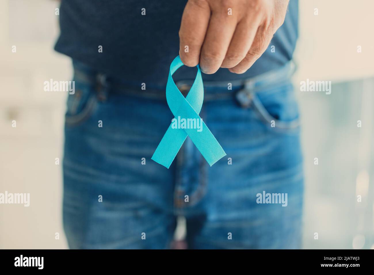 Senior man holding a blue cancer awareness ribbon in hand Stock Photo ...