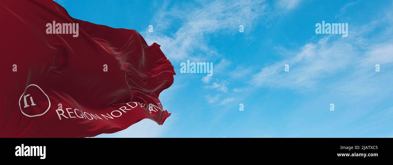 official flag of Region Nordjylland , Denmark at cloudy sky background ...