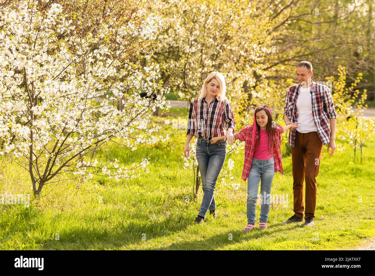 Happy family spending good time together in spring in a flowering ...