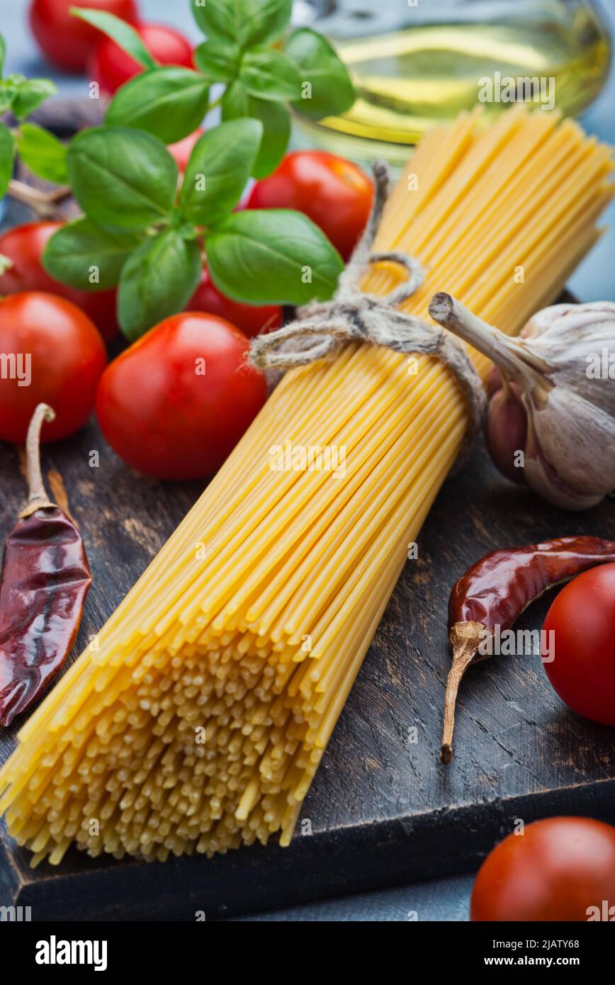 Italian food background with vine tomatoes, basil, spaghetti, olive oil ...