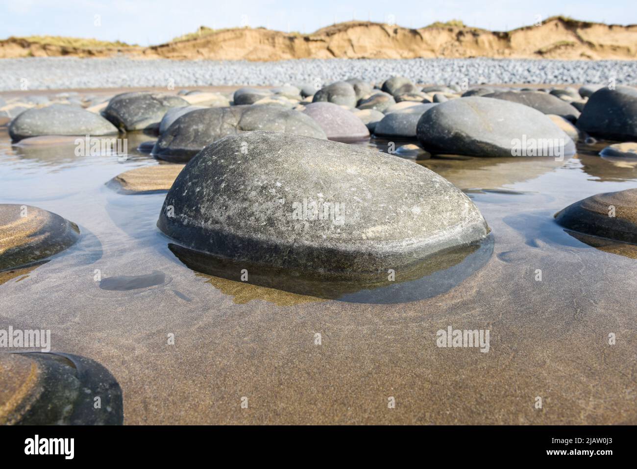 Pebbles in rock pools at the beach formed at low tide Stock Photo - Alamy