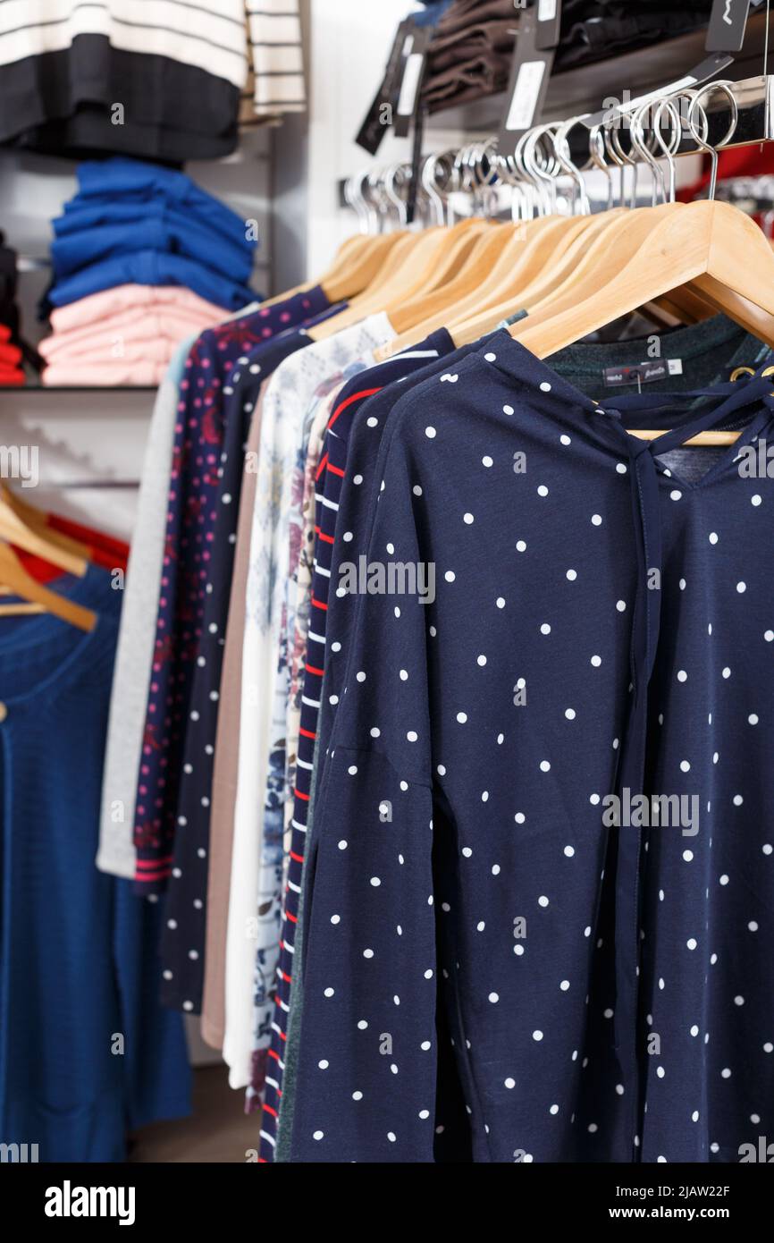 Stand with various clothes in clothing shop Stock Photo - Alamy