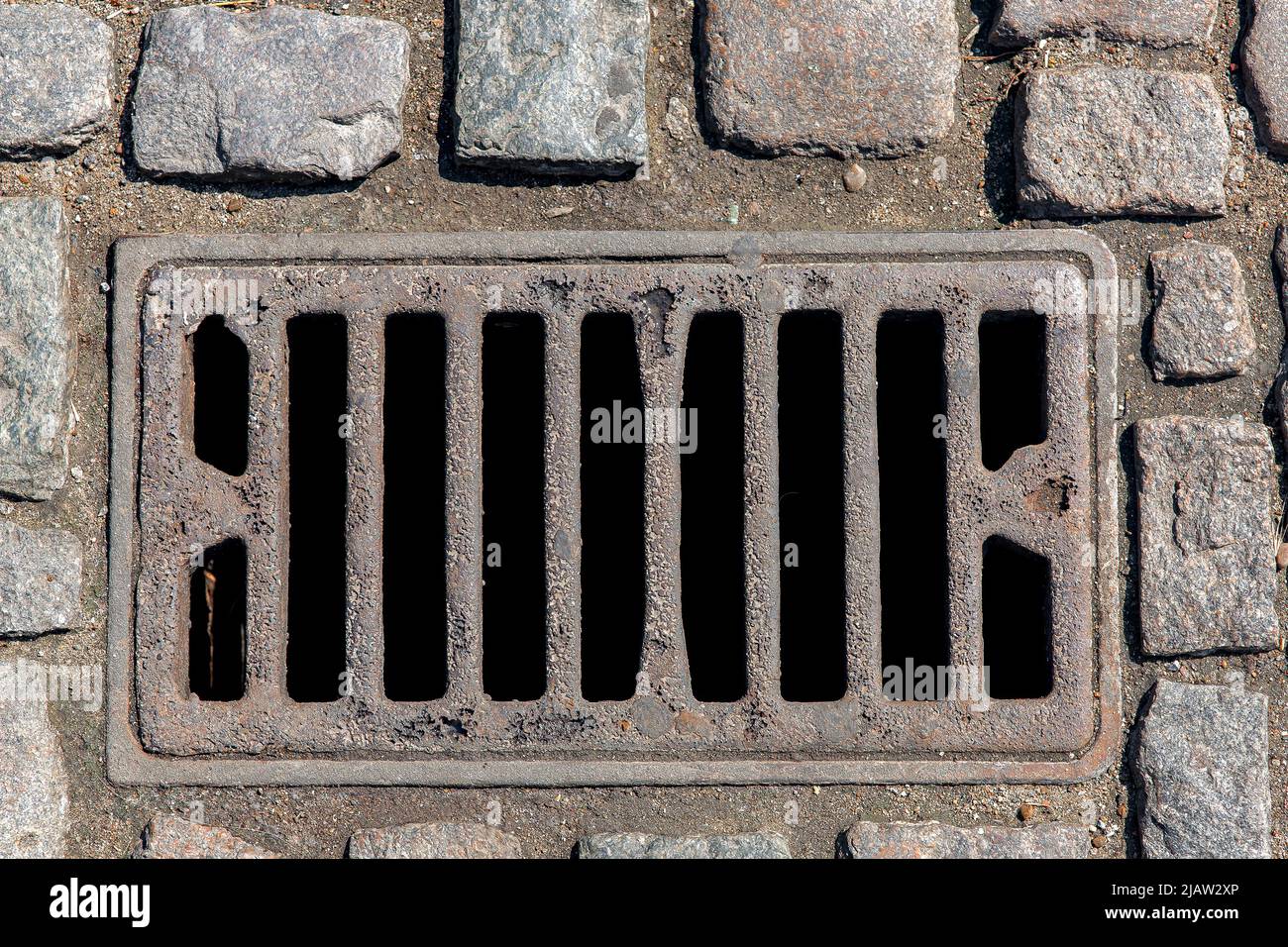 rusted rectangular grating manhole drainage system on the pavement road ...