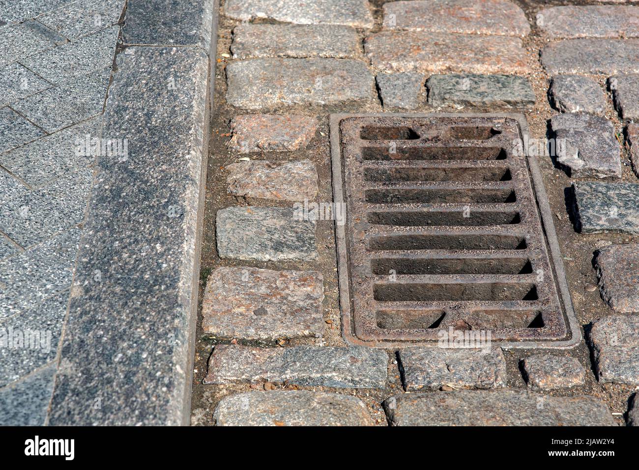 rusted rectangular grating manhole drainage system on the pavement road ...