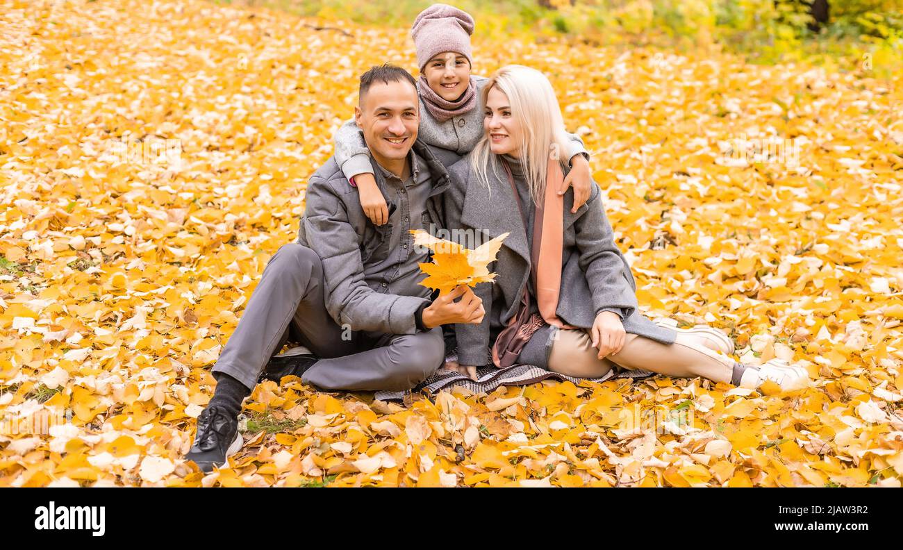 The family walks in the autumn forest and enjoys the autumn colors ...