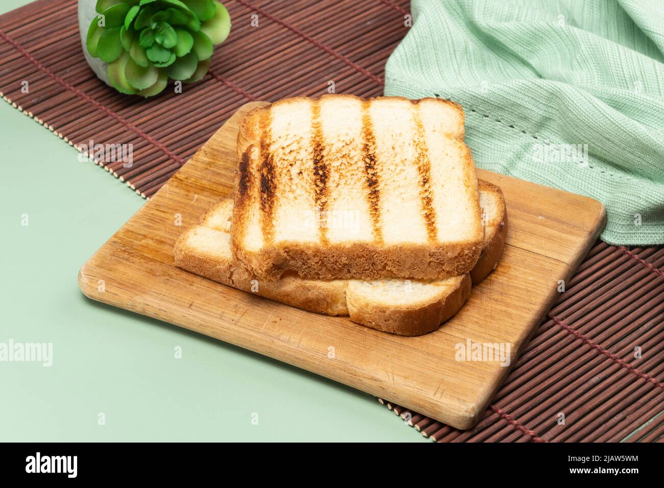 loaf of bread toast on top of wooden board and green background Stock ...