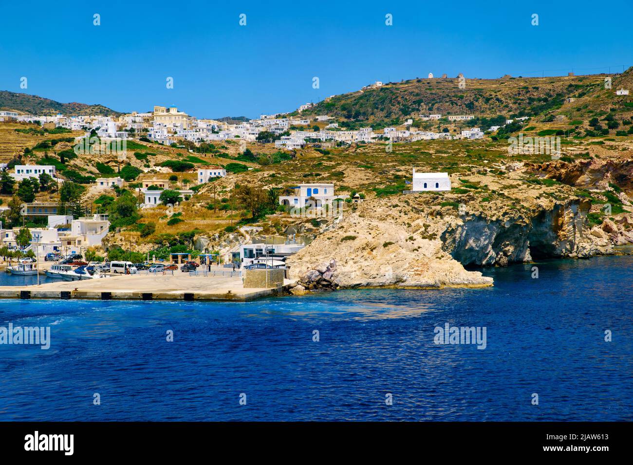 Beautiful summer day of Greek island town by seafront. Whitewashed ...