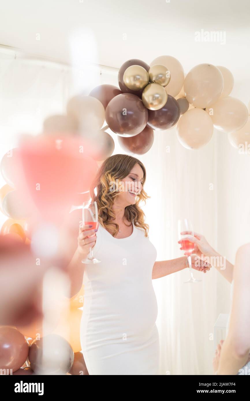 Happy woman celebrating with pink drink at baby shower party Stock ...