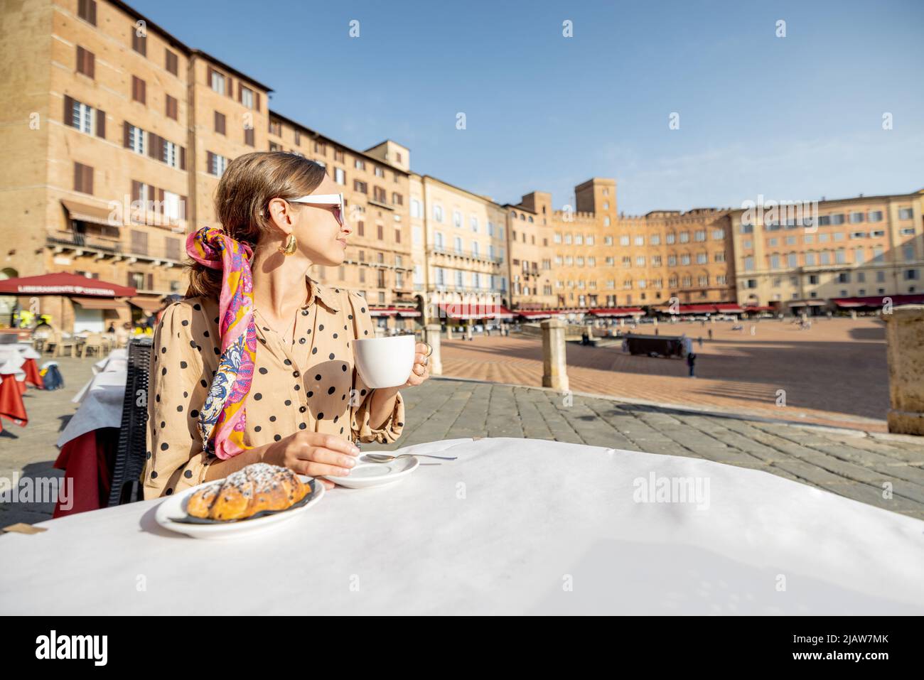 Woman having breakfast at outdoor cafe with beautiful view on main ...
