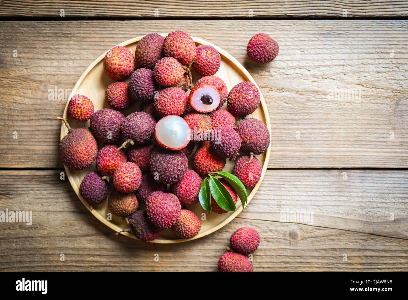 Lychee frui with green leaf on wooden plate background top view, fresh ...