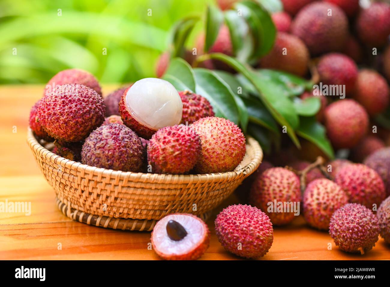 Lychee fruit on basket with green leaf and wooden background, fresh ...