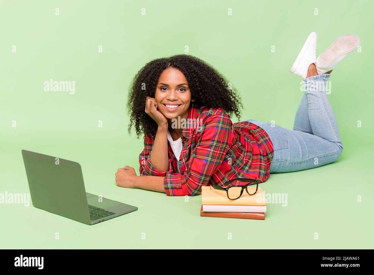 Full size profile side photo of young cheerful woman lying floor use laptop academic lesson ...