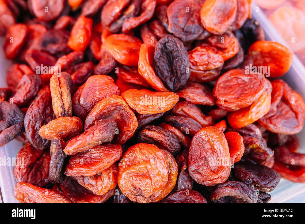 Lot of sweet candied dried apricots from dried fruits on the counter of ...