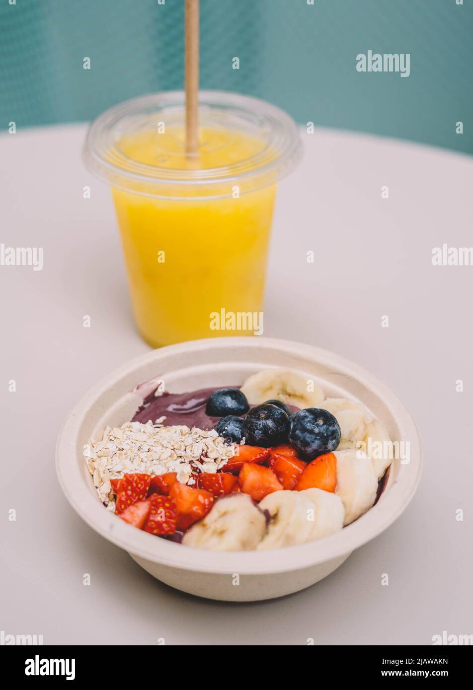 A plate of sliced fruits like an acai bowl accompanied by a natural ...