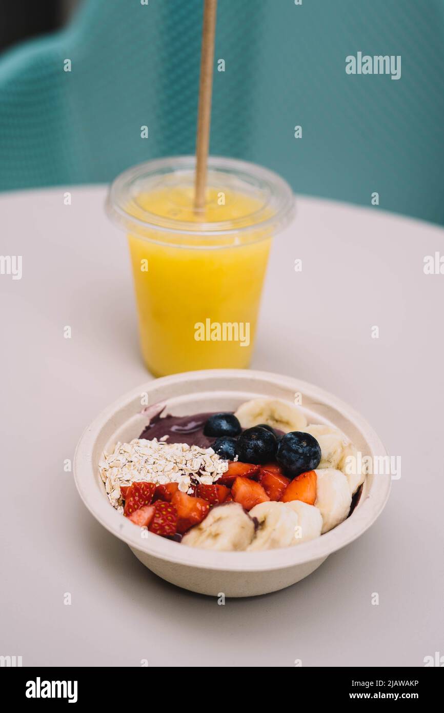 A plate of sliced fruits like an acai bowl accompanied by a natural ...