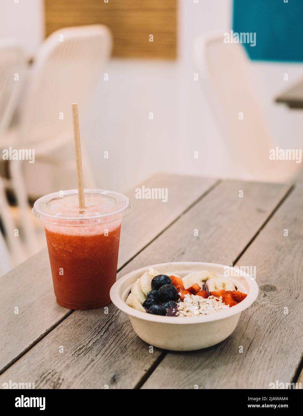 A plate of sliced fruits like an acai bowl accompanied by a natural ...