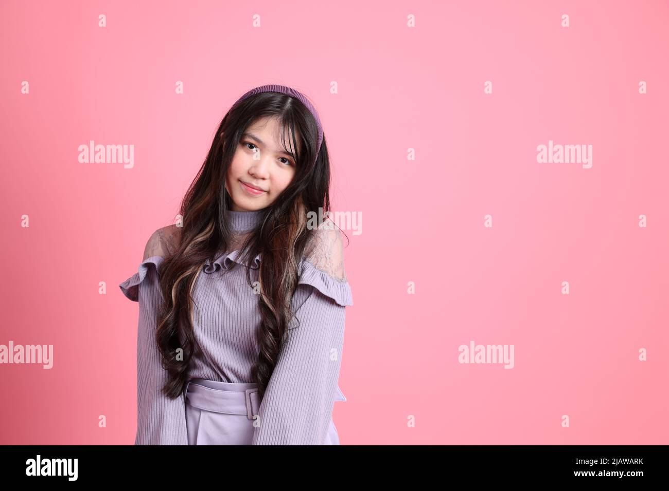 The cute young Asian woman with preppy dressed standing on the pink ...