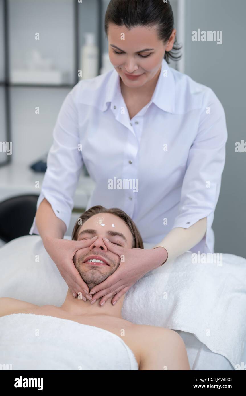 Young man having face massage in a spa salon Stock Photo - Alamy