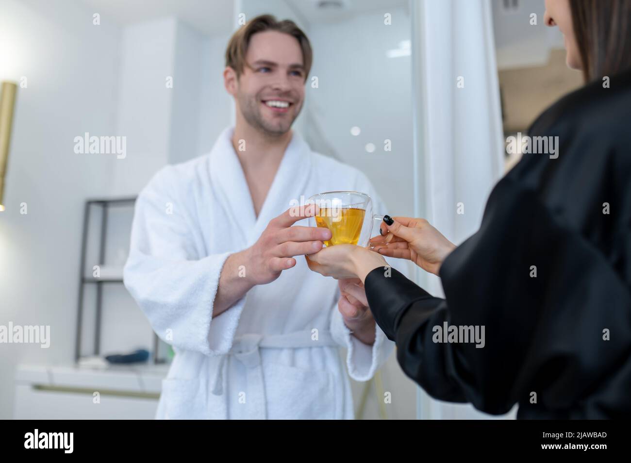 Service lady giving a cup of tea to the cleint in a spa salon Stock ...