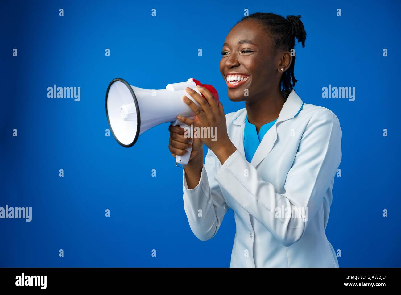 Afro american female doctor in white medical gown scream in megaphone ...