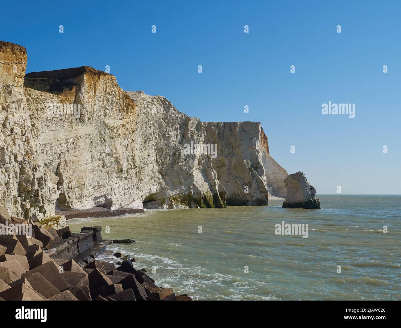 A coast of white cliffs - strata clearly visible - and a rock outcrop ...