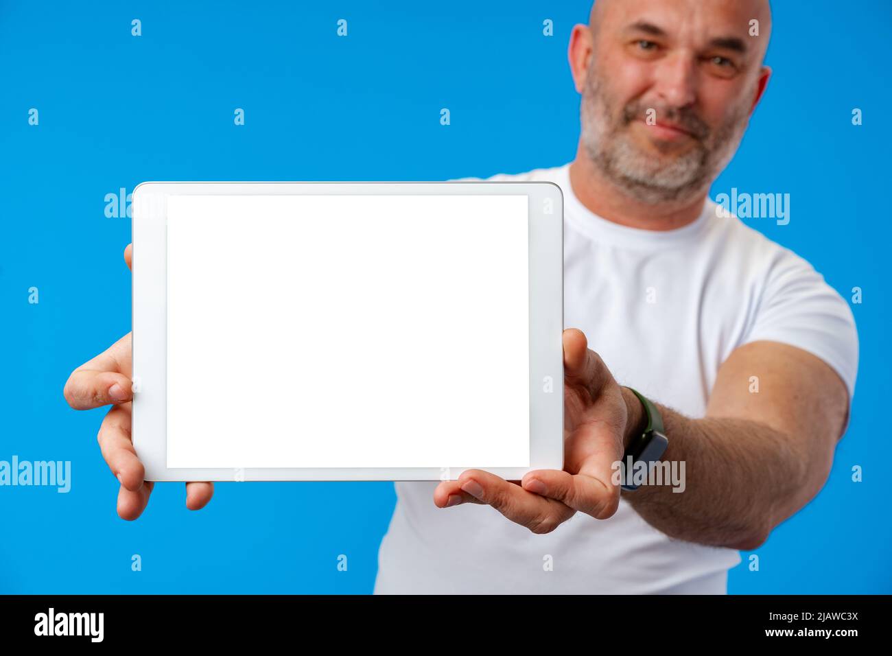 Happy caucasian middle-aged man showing tablets screen over blue ...