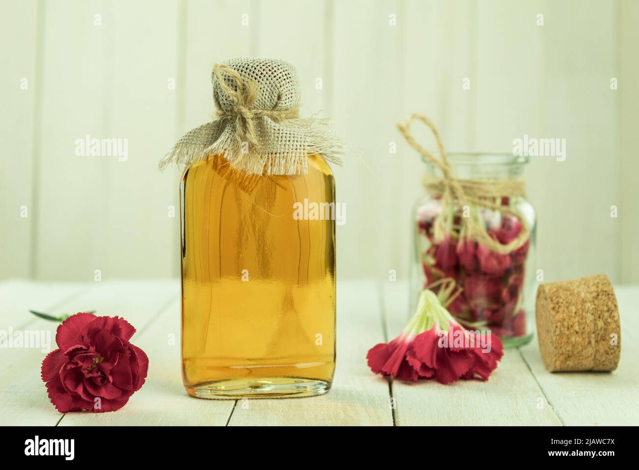 A bottle of aromatic oil made from fresh flower petals. Essential oil ...