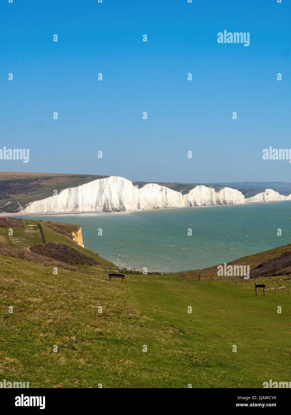 Sunlit white chalk cliffs under summery blue skies near Seaford, with a ...